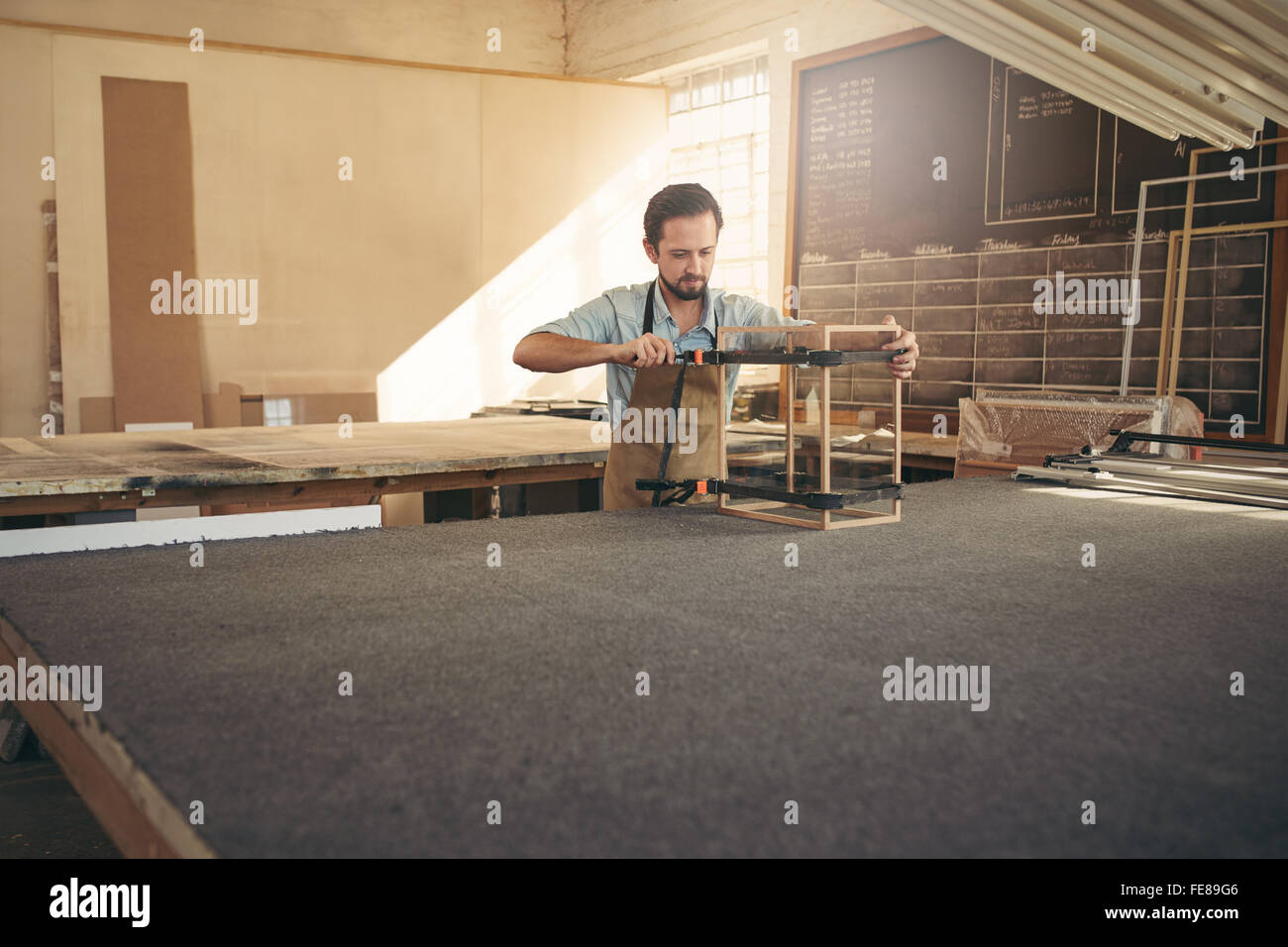 Carpenter's workshop with a craftsman building a display case from wood ...