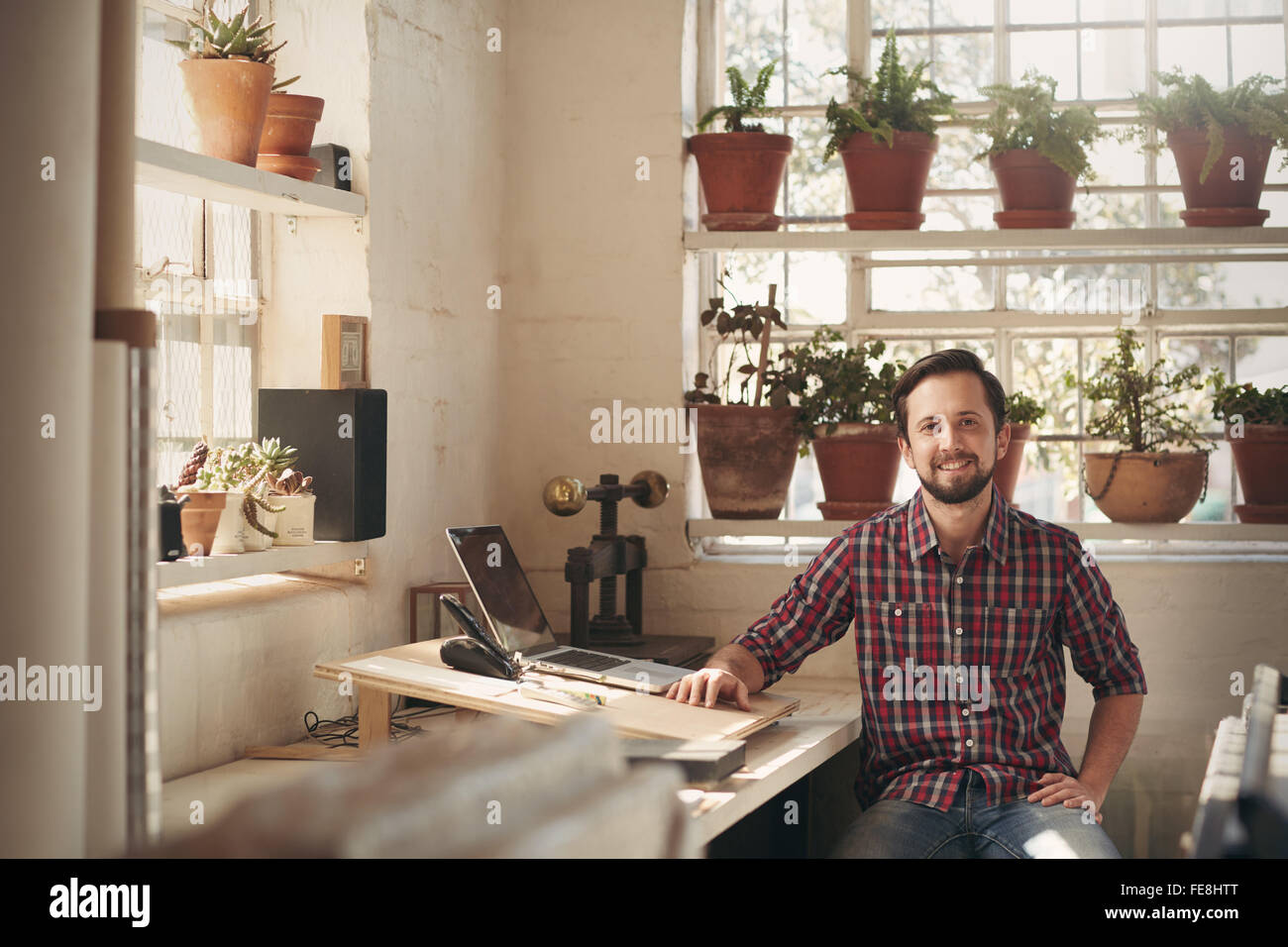 Young male designer sitting comfortably in his office space in his ...