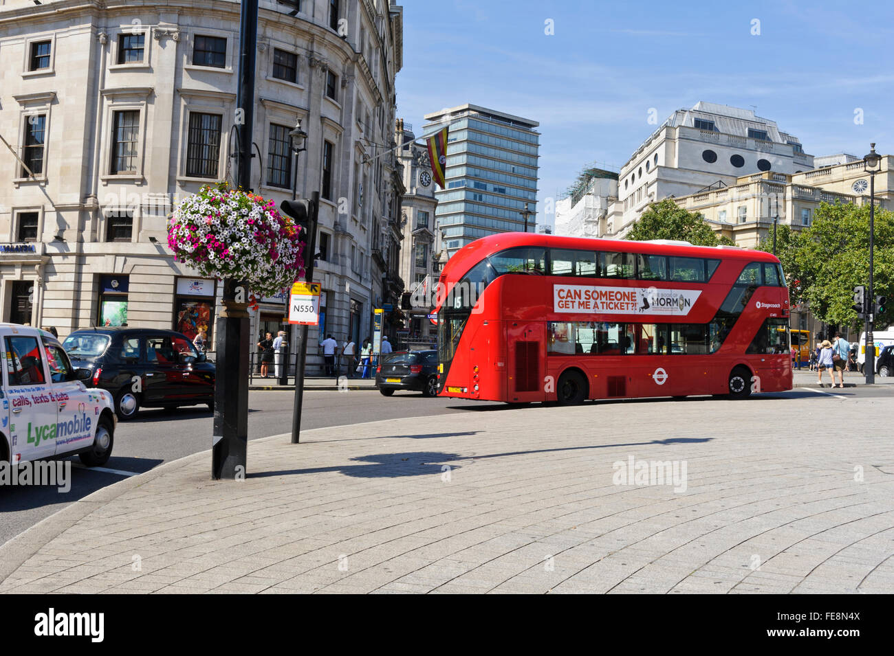 A modern red bus traveling near Trafalgar Square, London, United ...