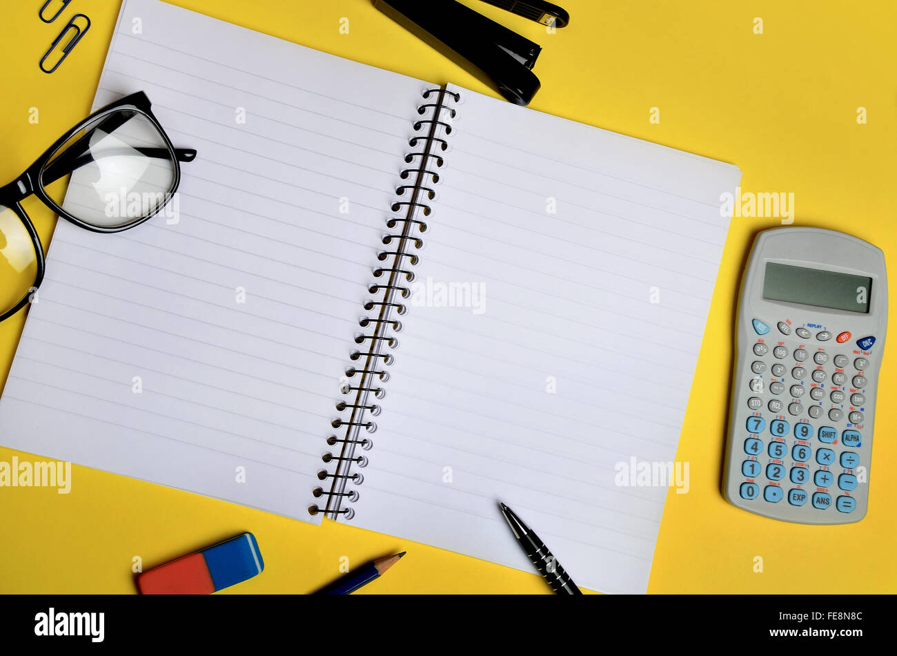 Assorted office supplies on yellow background Stock Photo - Alamy