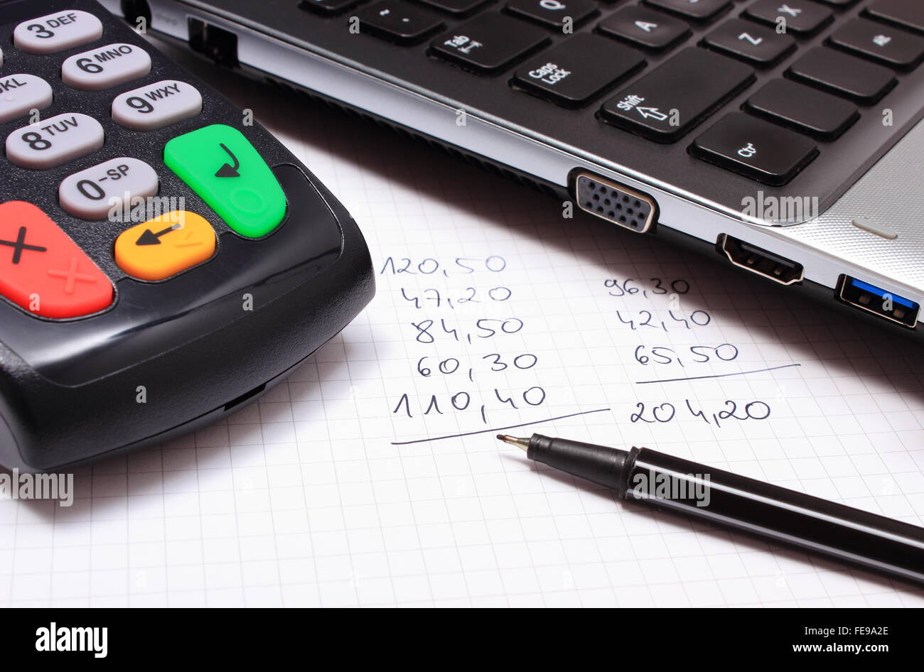 Payment terminal with laptop and financial calculations, credit card ...