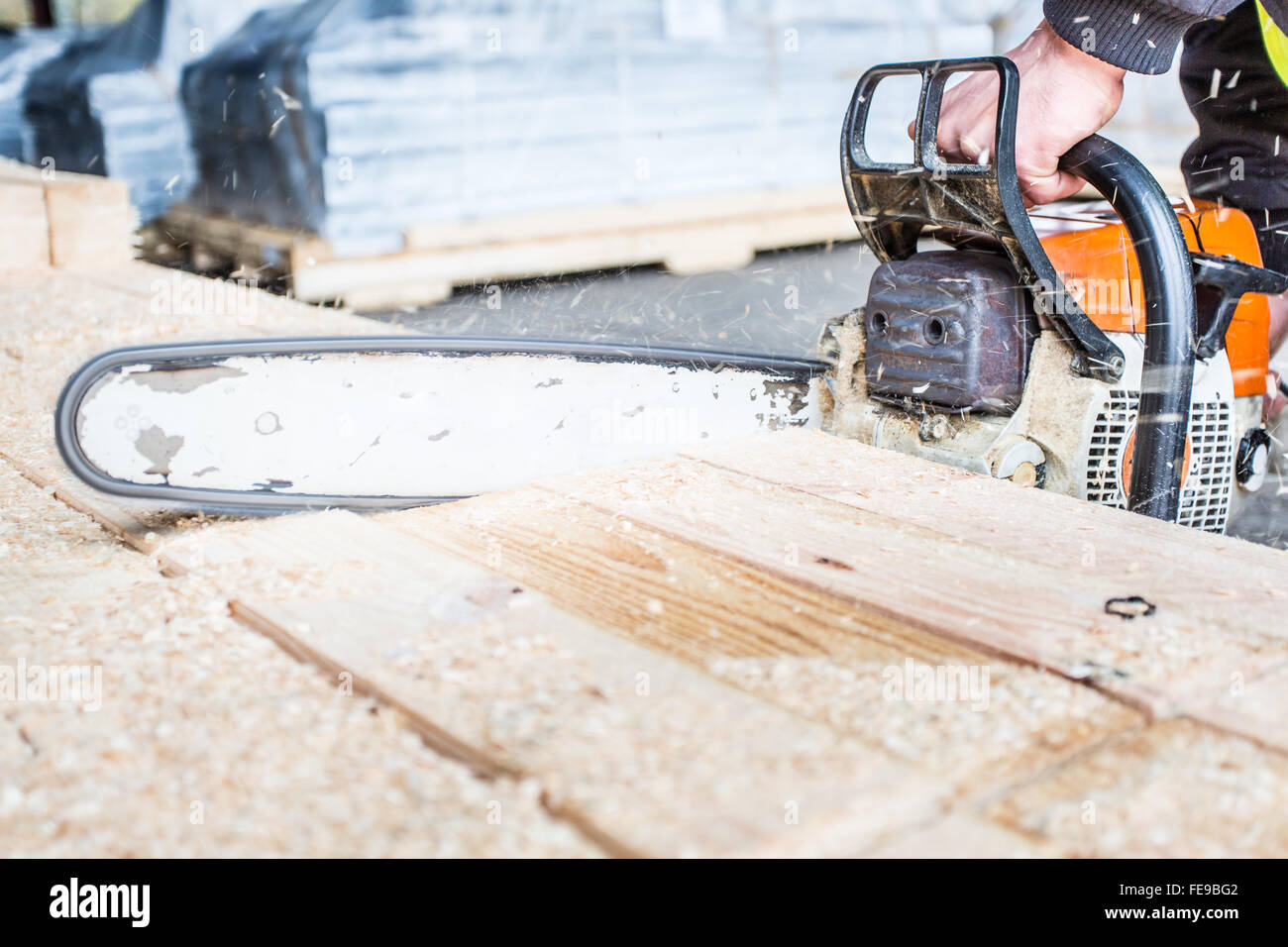 A Worker using a Chainsaw cutting Wood Stock Photo - Alamy