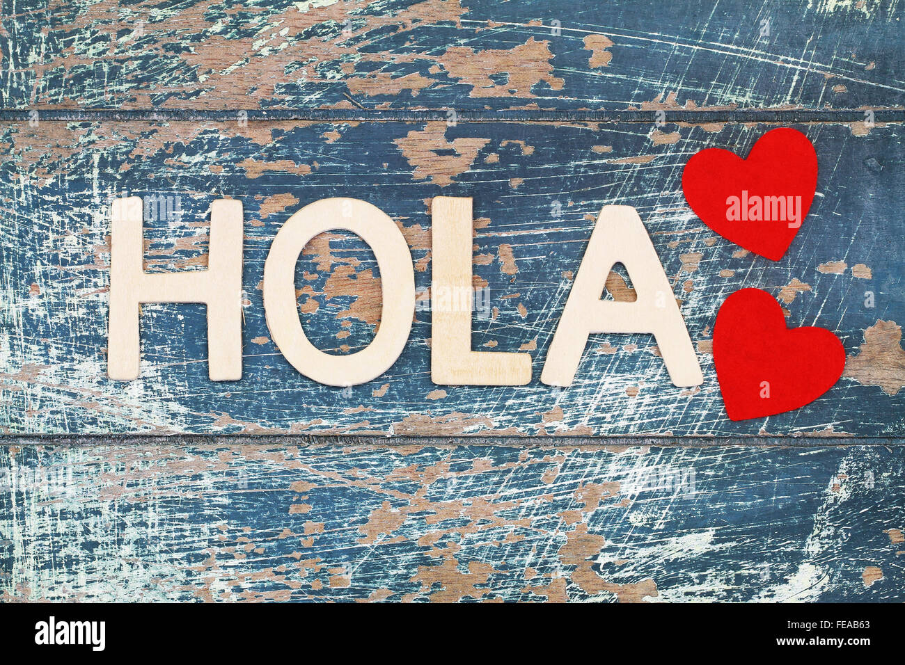 Hola (Hello in Spanish) written with wooden letters on rustic surface ...