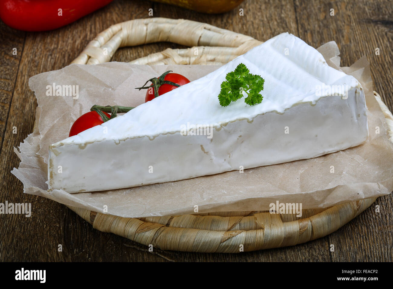 Brie cheese triangle with tomato and parsley Stock Photo - Alamy