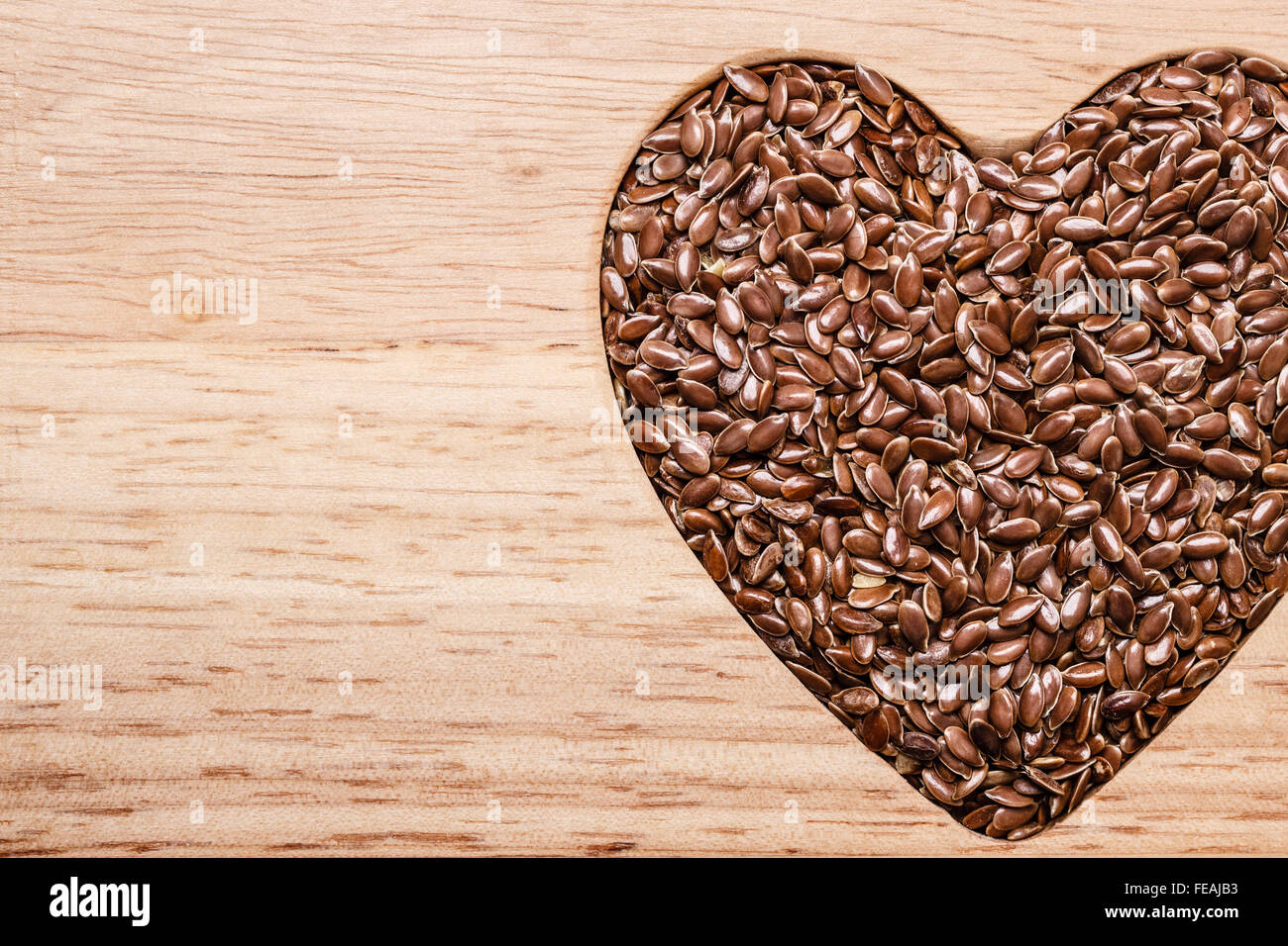 Diet healthcare healthy food. Raw flax seeds linseed heart shaped on wooden board background ...