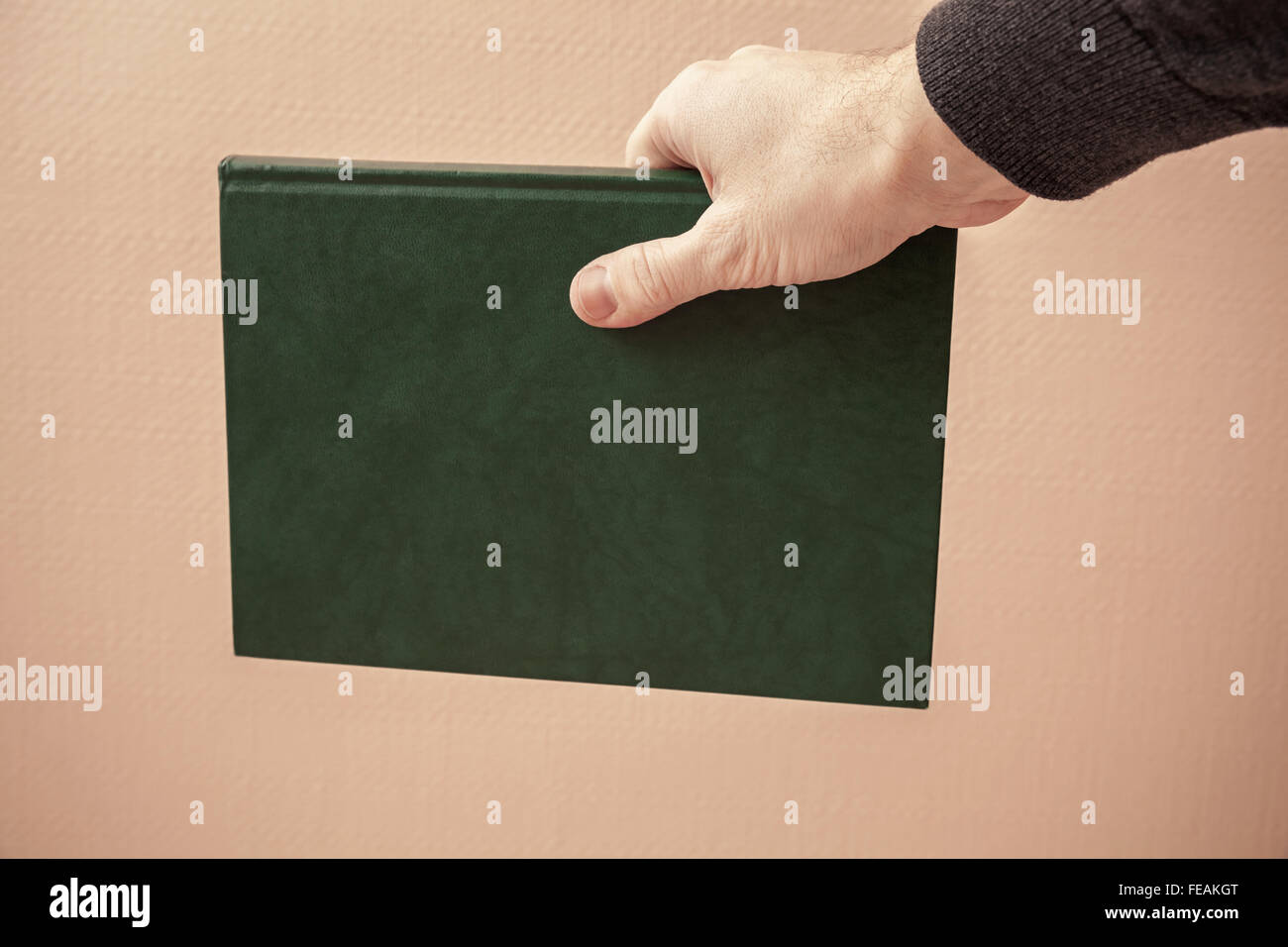 Book with empty dark green leather cover in hand Stock Photo - Alamy