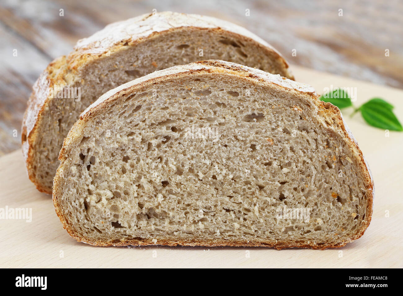 Rye bread cut in half on wooden board, closeup Stock Photo - Alamy