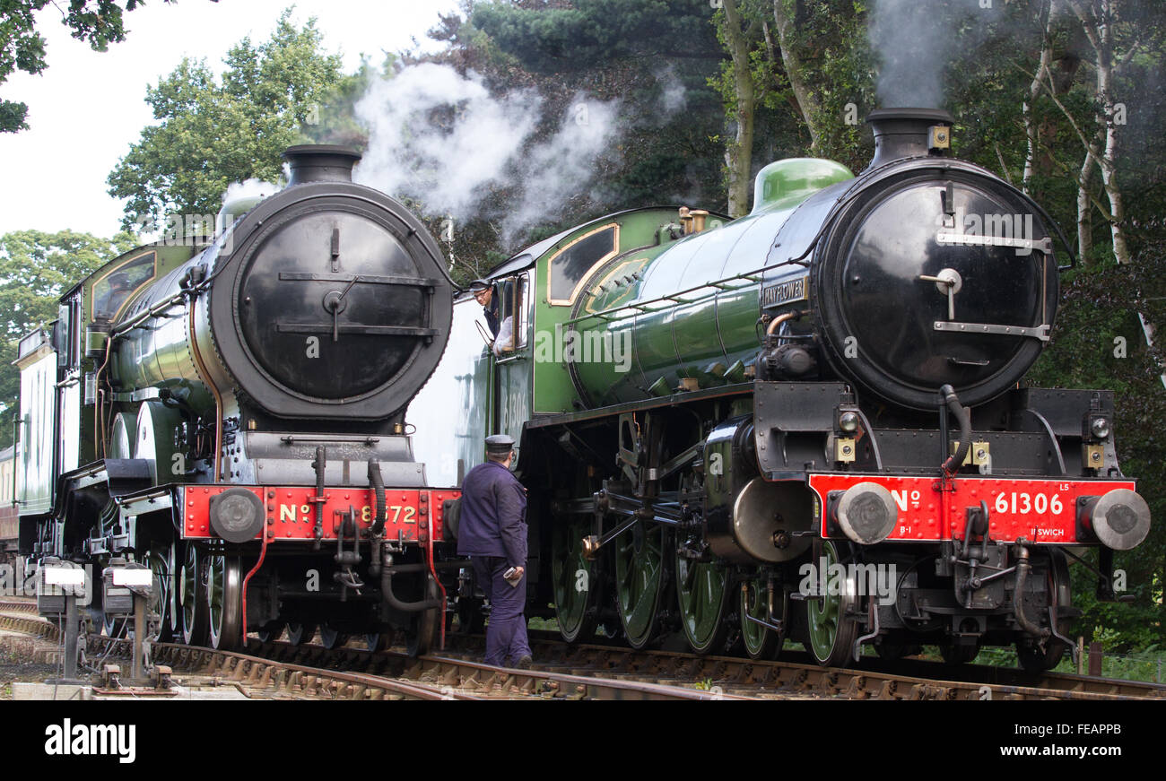 LNER 4-6-0 steam engines pass at Holt as a driver watches Stock Photo ...
