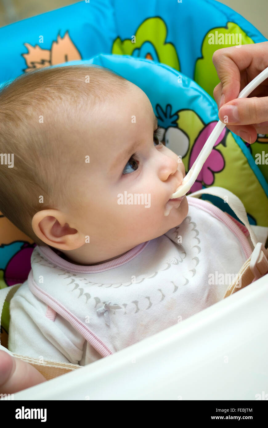 Baby girl being spoon fed Stock Photo - Alamy