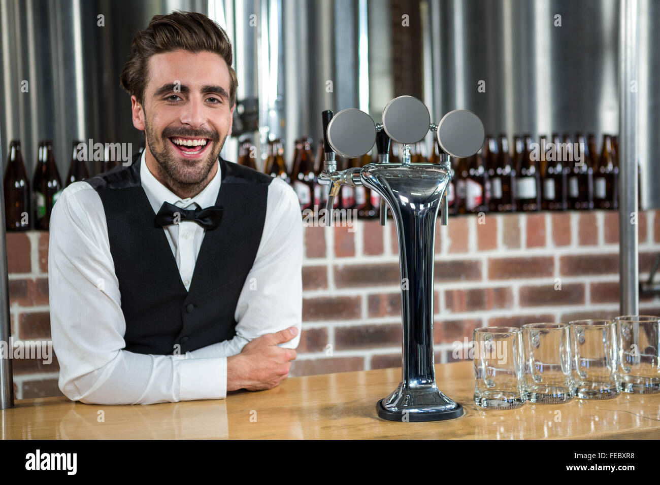 Handsome barman leaning on counter Stock Photo - Alamy