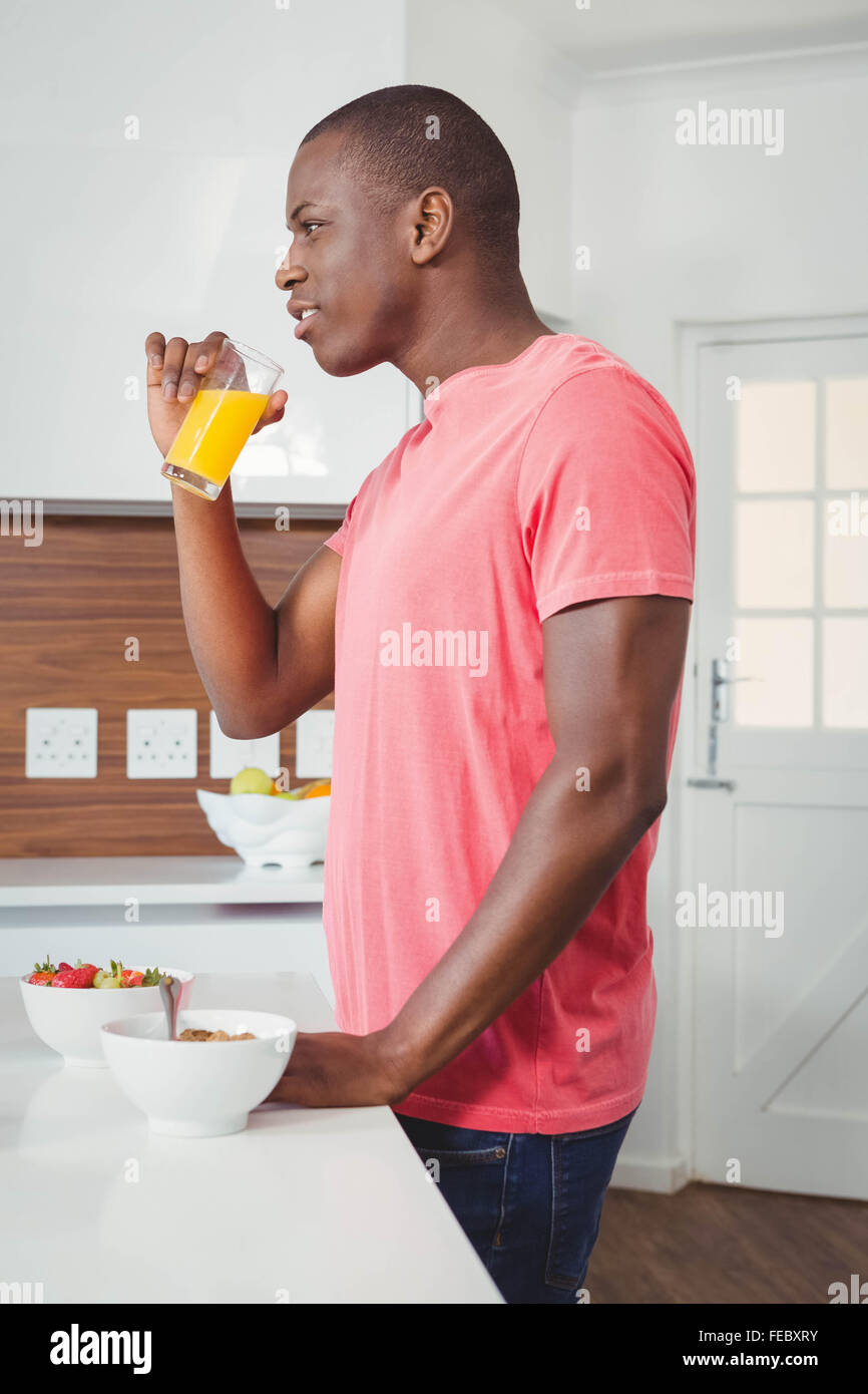 Handsome man drinking orange juice Stock Photo - Alamy
