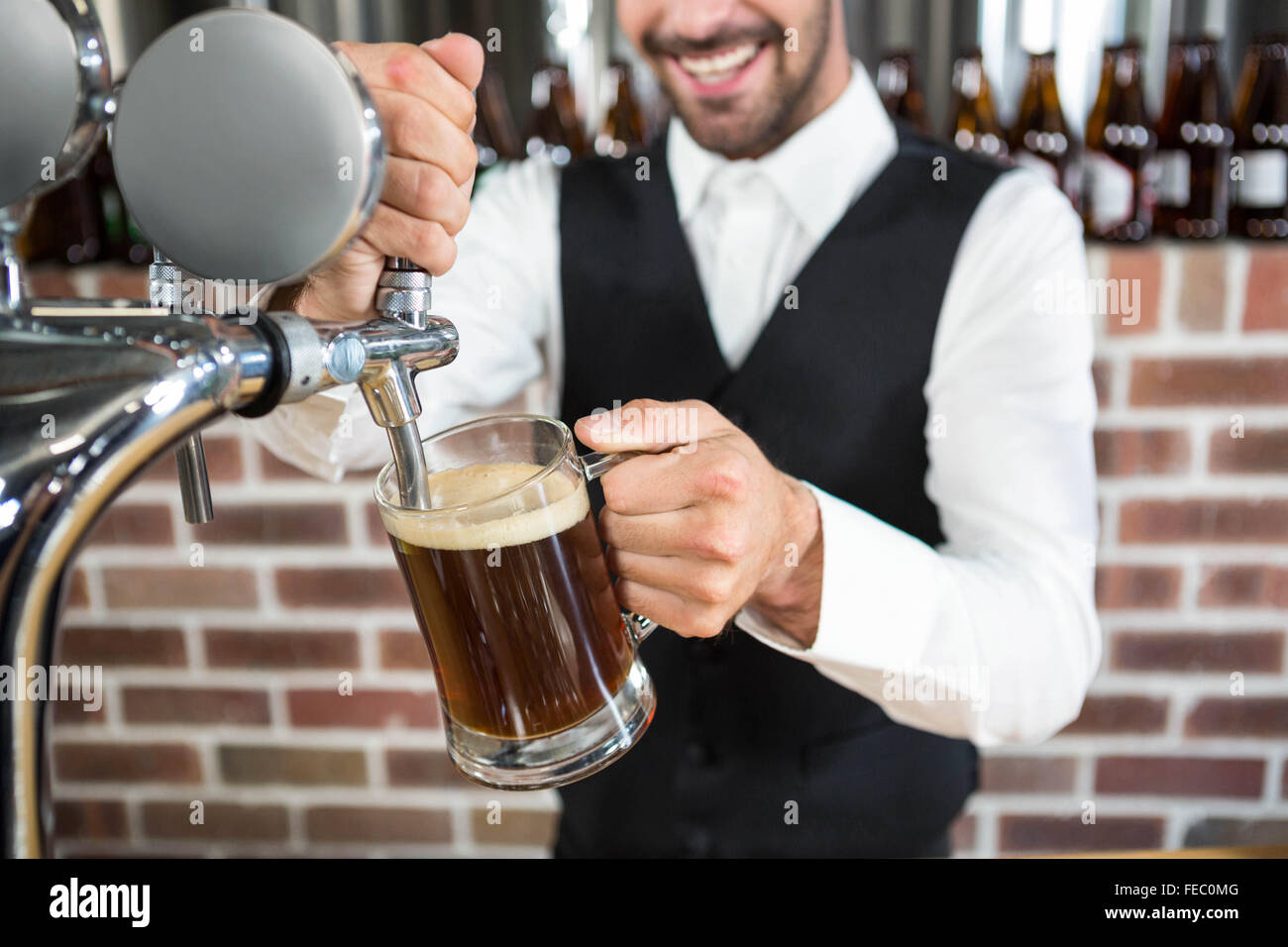 Handsome barman pouring beer Stock Photo - Alamy
