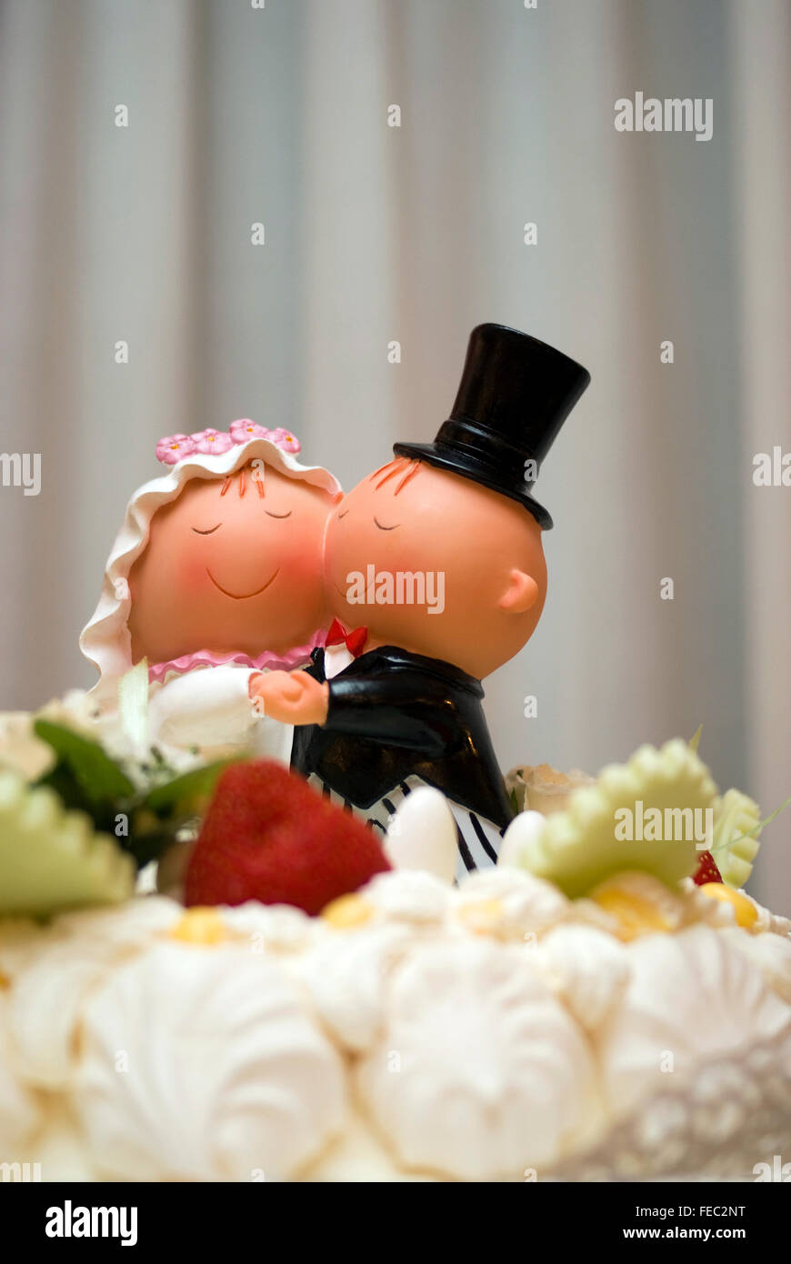 Comical bride and groom figurines on top of wedding cake Stock Photo ...