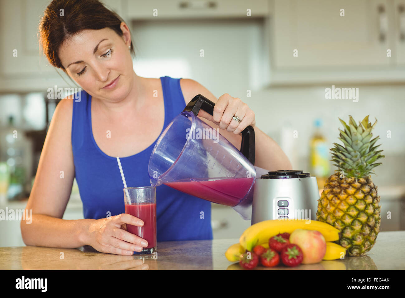 Smiling woman drinking smoothie Stock Photo - Alamy