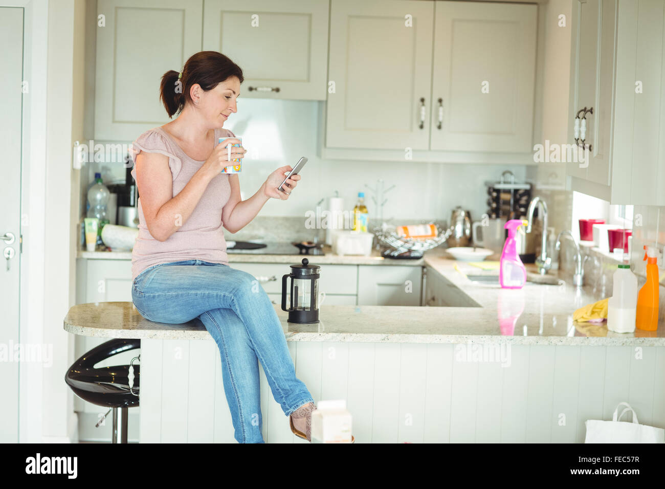 Woman sitting on the kitchen counter Stock Photo - Alamy