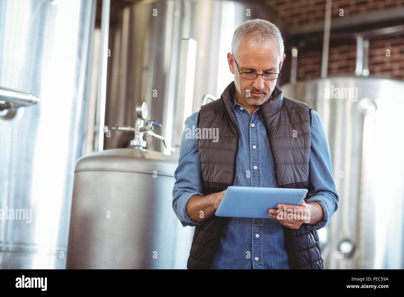 Local brewer using his tablet pc Stock Photo - Alamy