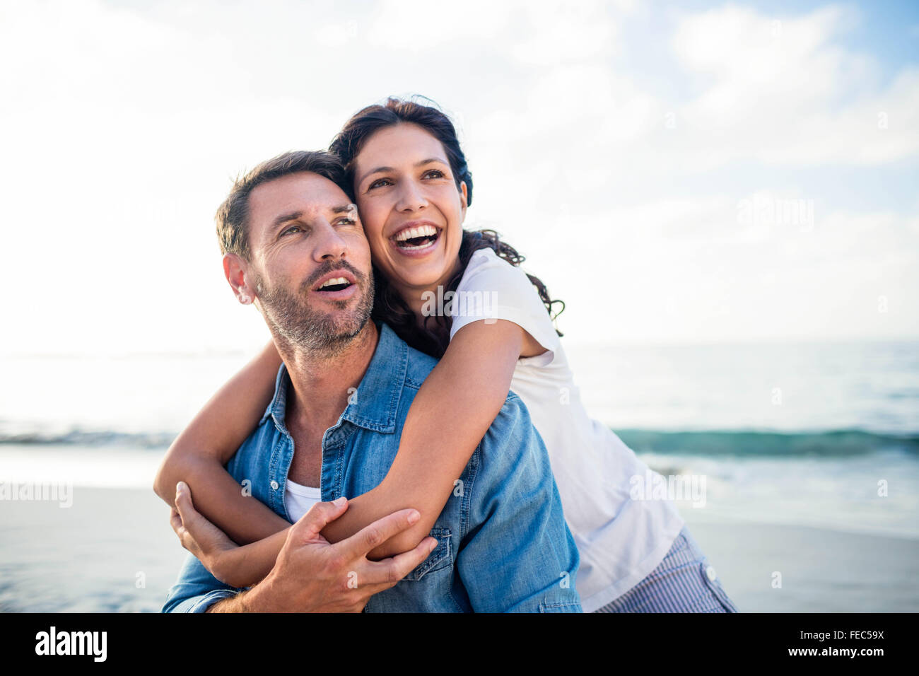 Cute couple cuddling with arms around Stock Photo - Alamy