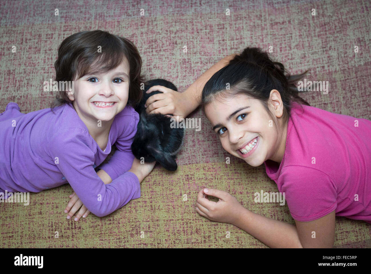 Girls playing with rabbit at home Stock Photo - Alamy