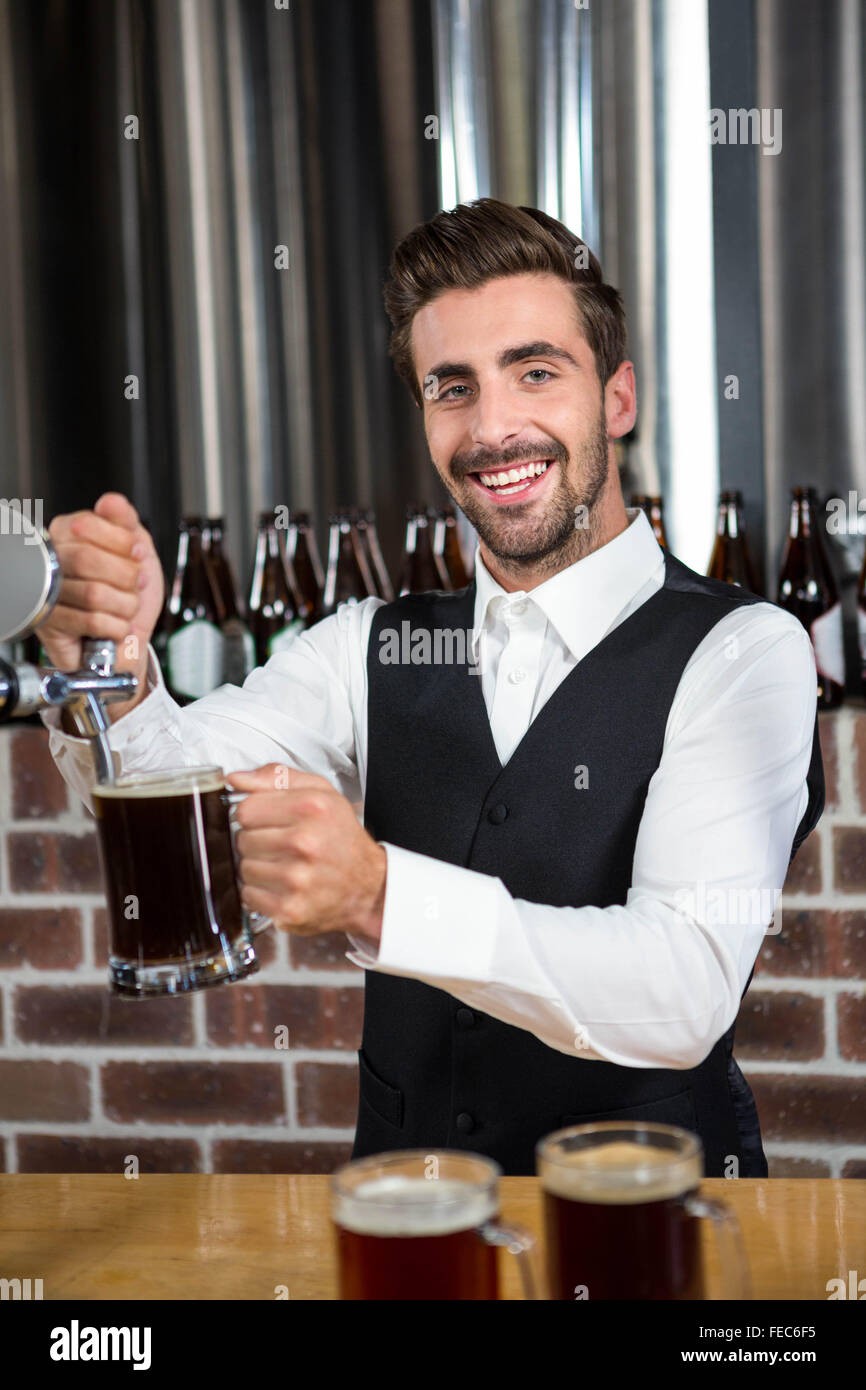 Handsome barman pouring a beer Stock Photo - Alamy