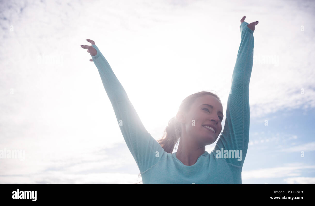 Happy fit brunette raising her arms Stock Photo - Alamy