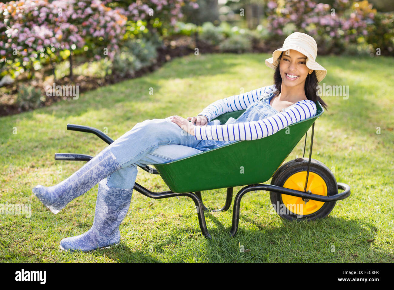 Gardener woman lying on a wheelbarrow Stock Photo - Alamy