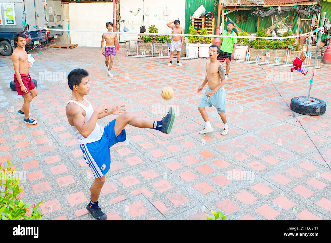 Thai men and boys playing Sepak Takraw or Kick Volleyball a volleyball ...