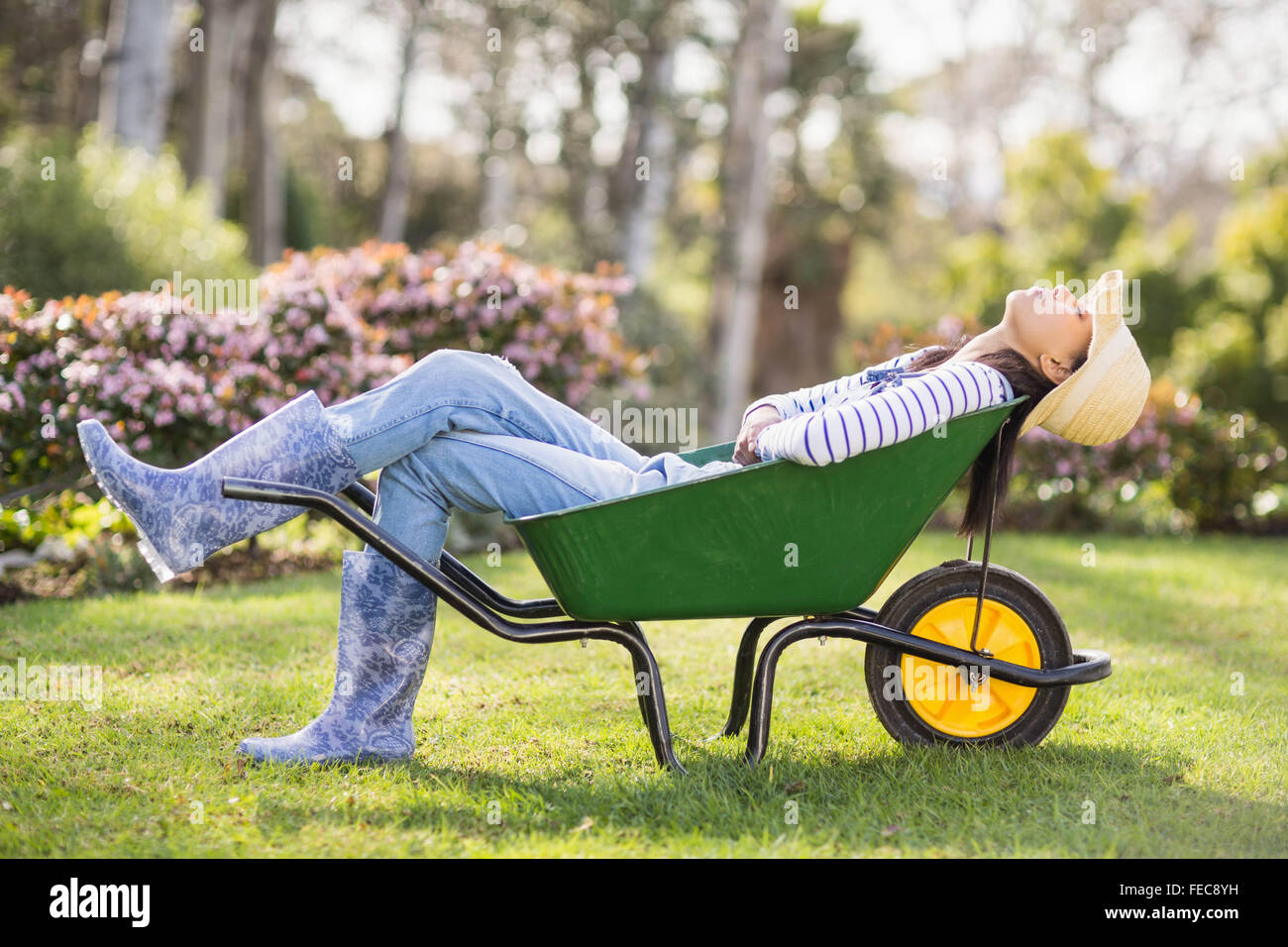 Gardener woman lying on a wheelbarrow Stock Photo - Alamy