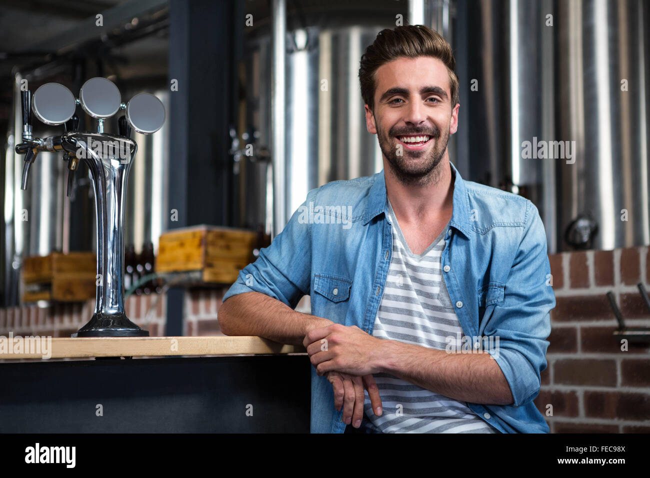 Handsome man leaning his elbow on the counter Stock Photo - Alamy