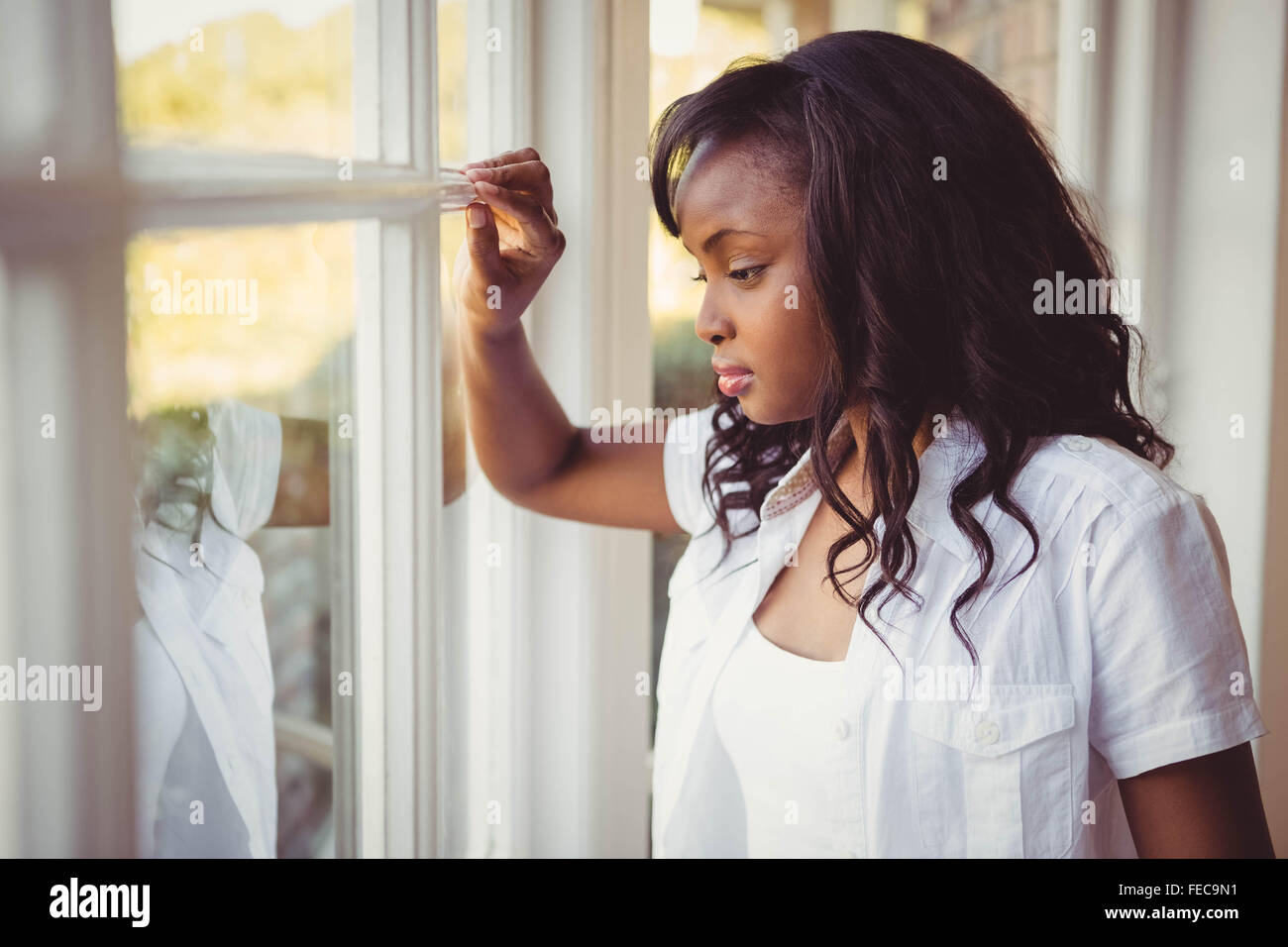 Pretty woman looking through the window Stock Photo - Alamy