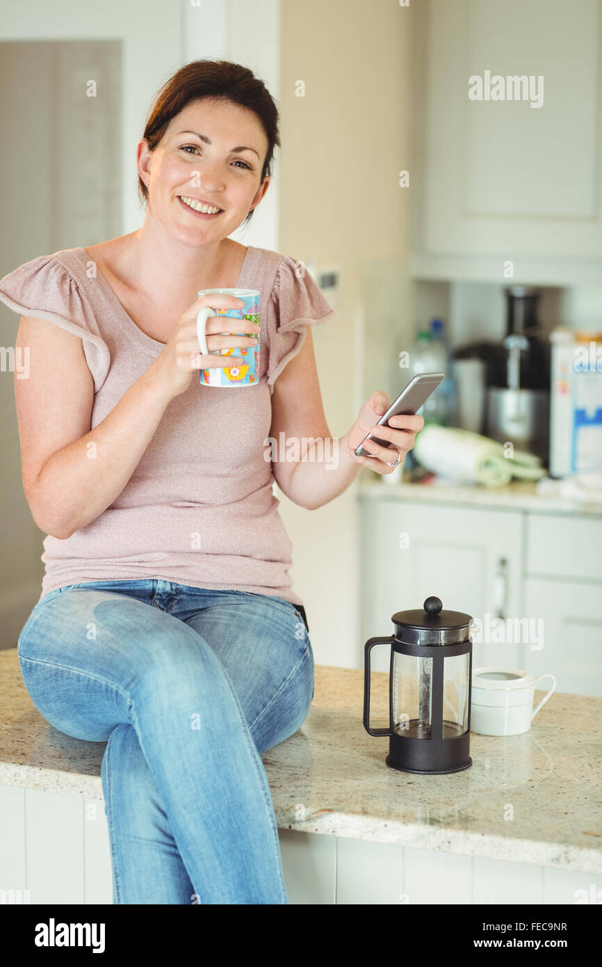 Woman sitting on the kitchen counter Stock Photo - Alamy