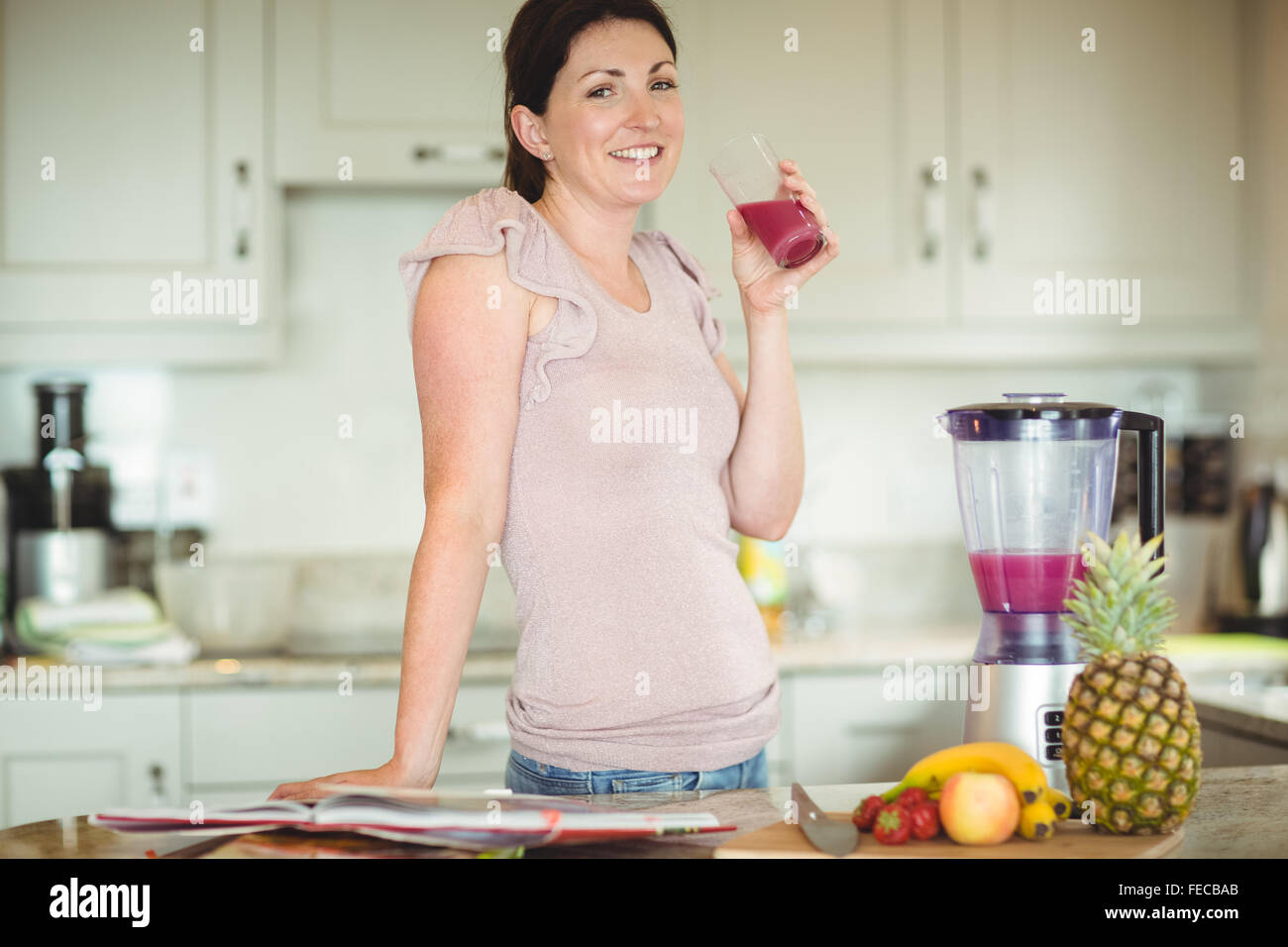 Smiling woman drinking smoothie Stock Photo - Alamy