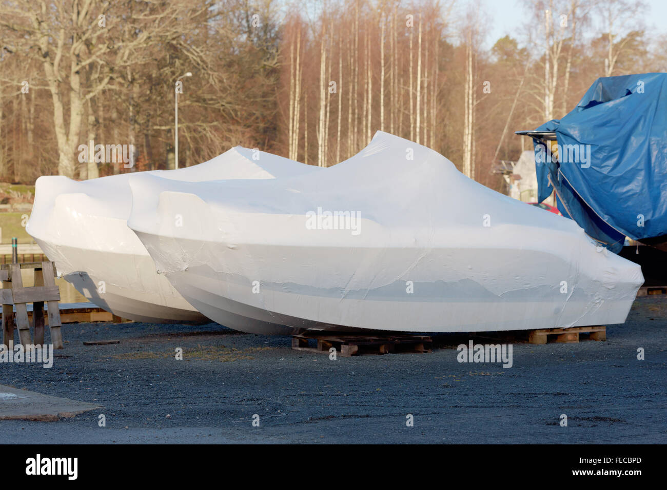 Newly manufactured boats incased in plastic shrink wrapping ready for ...