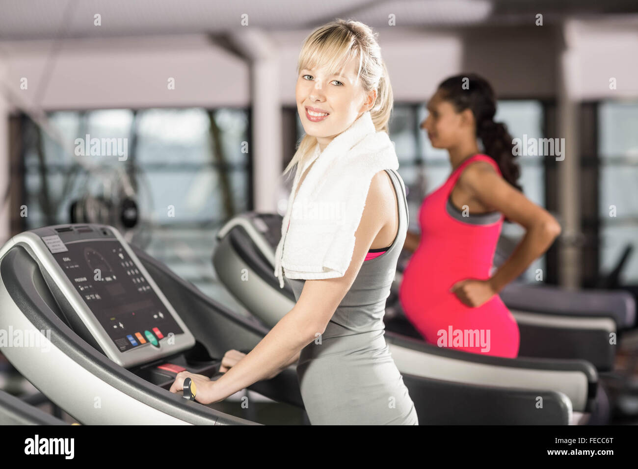 Smiling woman on treadmill looking at the camera Stock Photo - Alamy