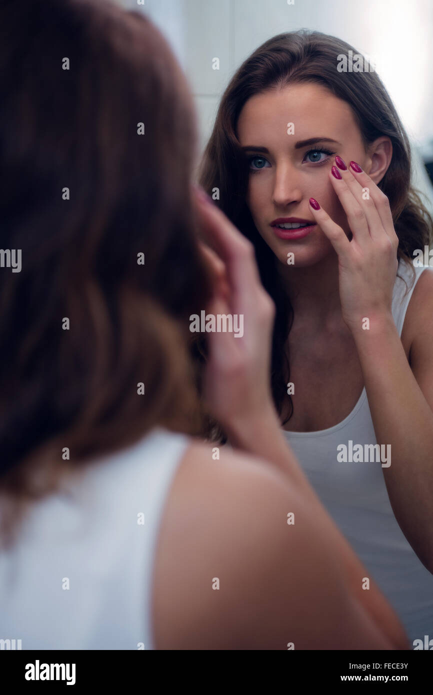 Beautiful brunette looking at herself in the bathroom mirror Stock ...