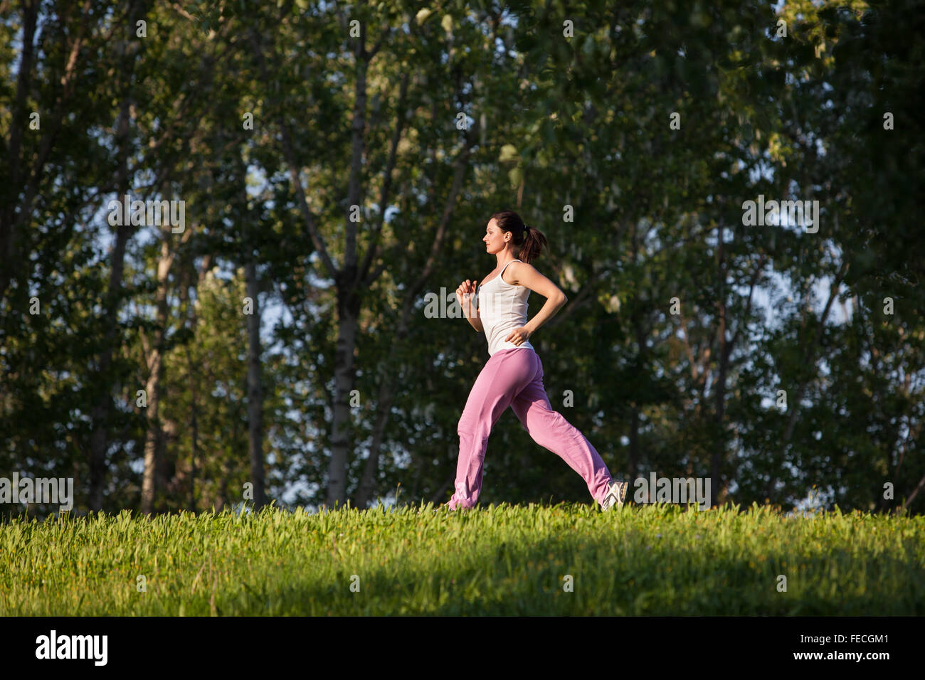 Young Woman Running Through The Park Stock Photo - Alamy