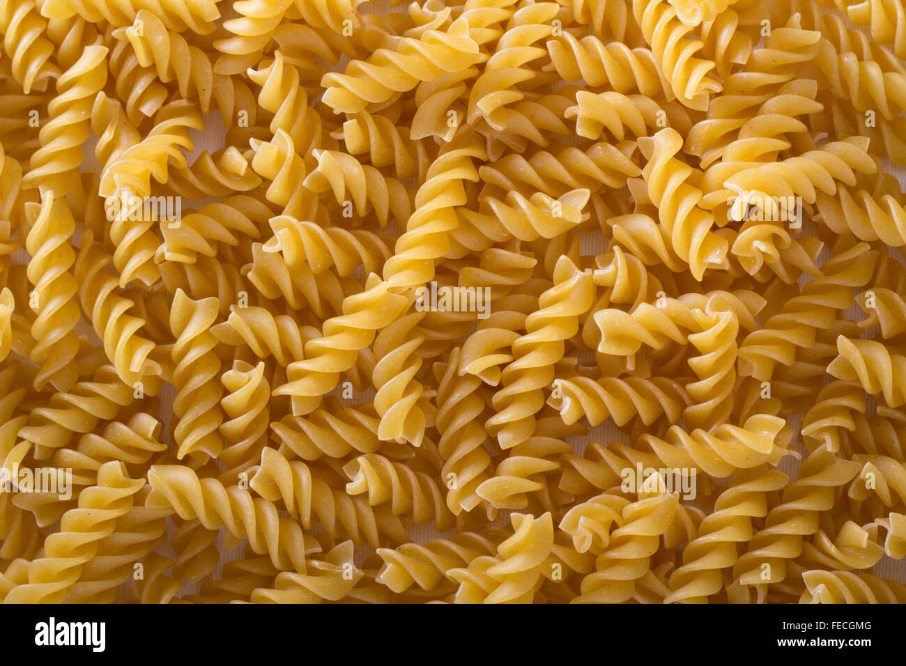 Pasta fusilli background with small pasta shapes Stock Photo - Alamy