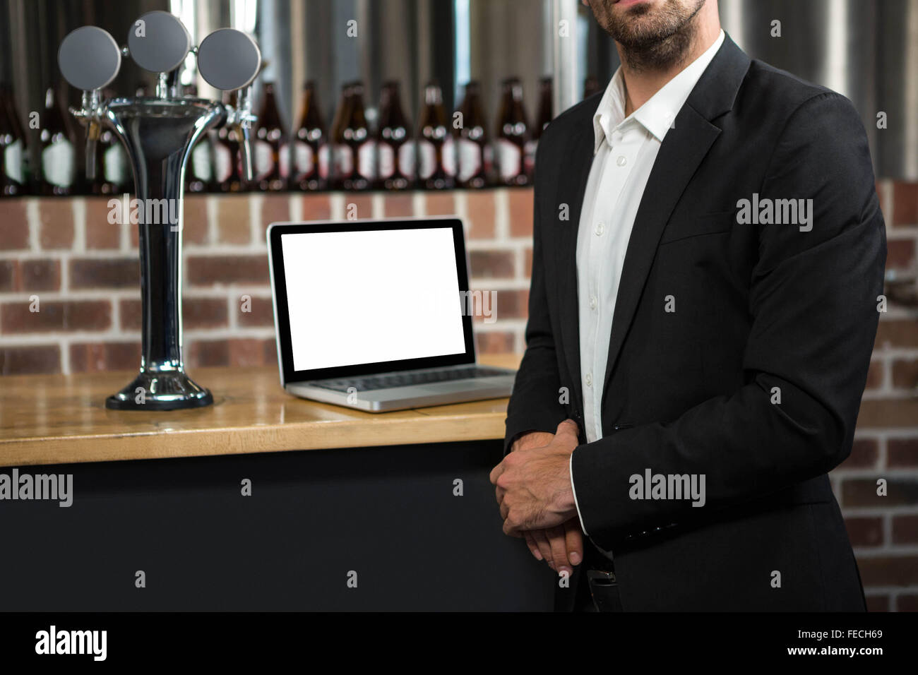 Businessman standing at bar with laptop Stock Photo - Alamy