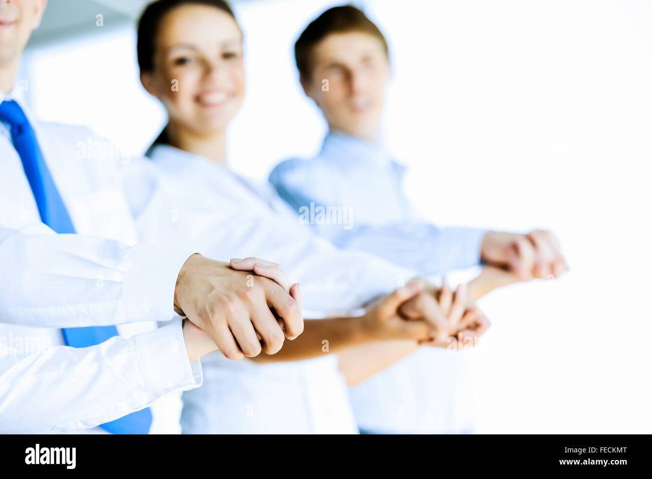 Image of group of businesspeople holding arms together. Teamwork Stock ...