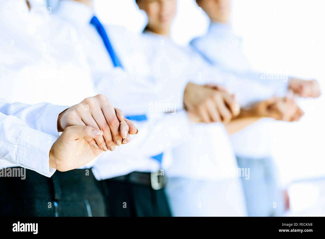 Image of group of businesspeople holding arms together. Teamwork Stock ...