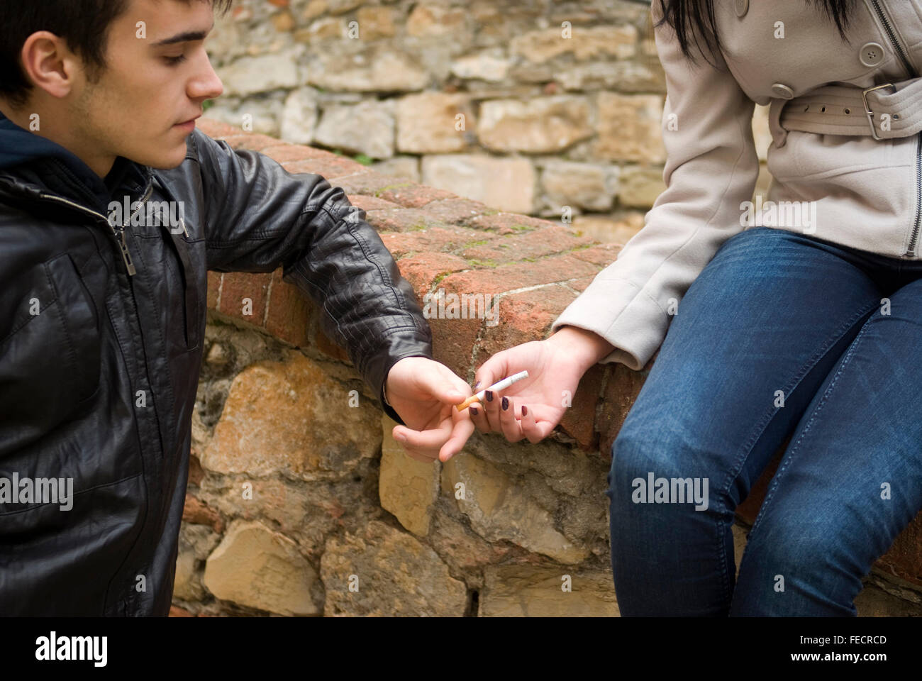 Cropped view of two teenage smoking a cigarette Stock Photo - Alamy