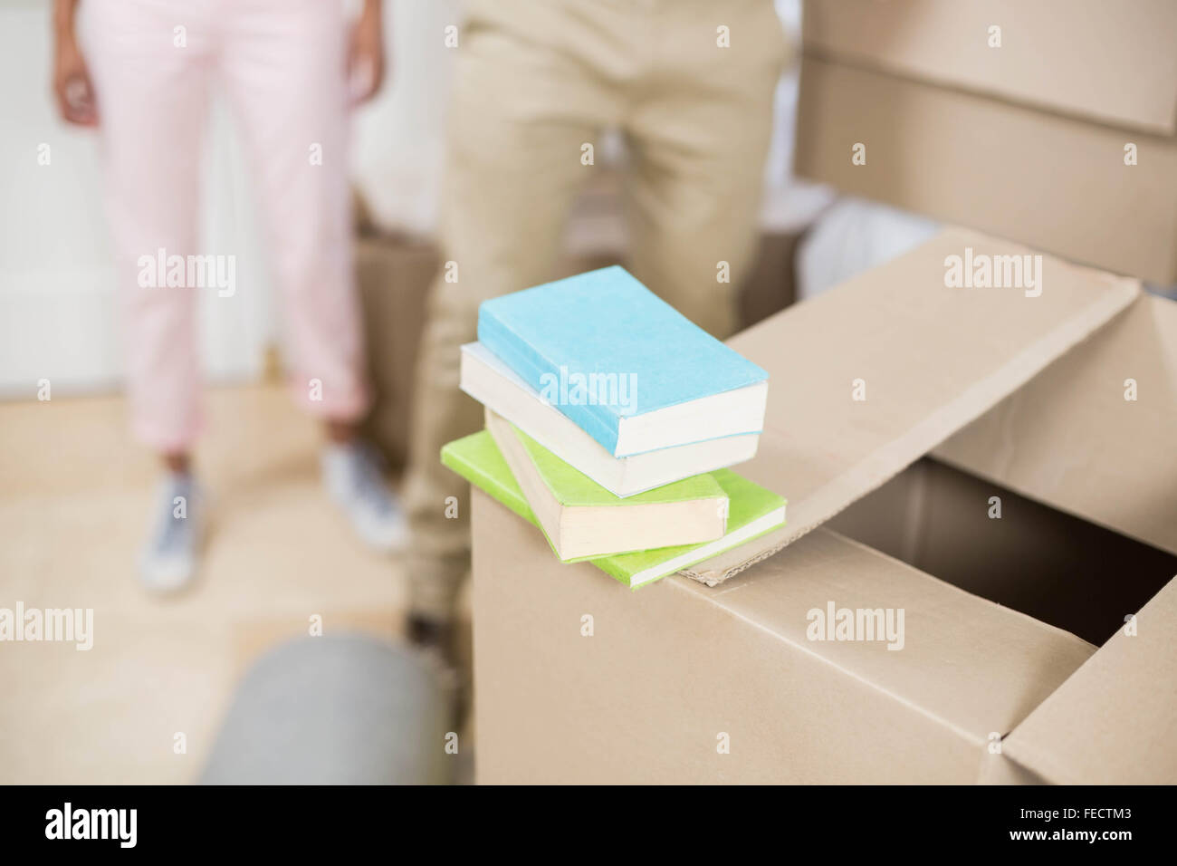 Books lay on a cardboard box with couple in background Stock Photo - Alamy
