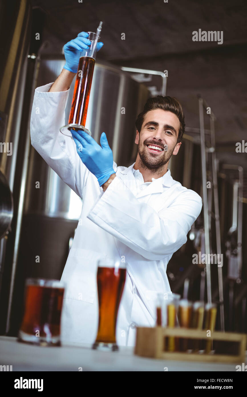 Happy brewer checking beaker of beer Stock Photo - Alamy