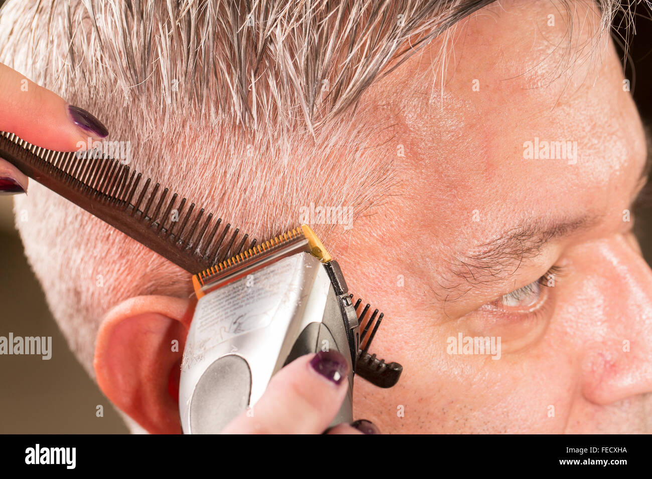 woman cuts hair with scissors, razor in professional hairdressing salon ...