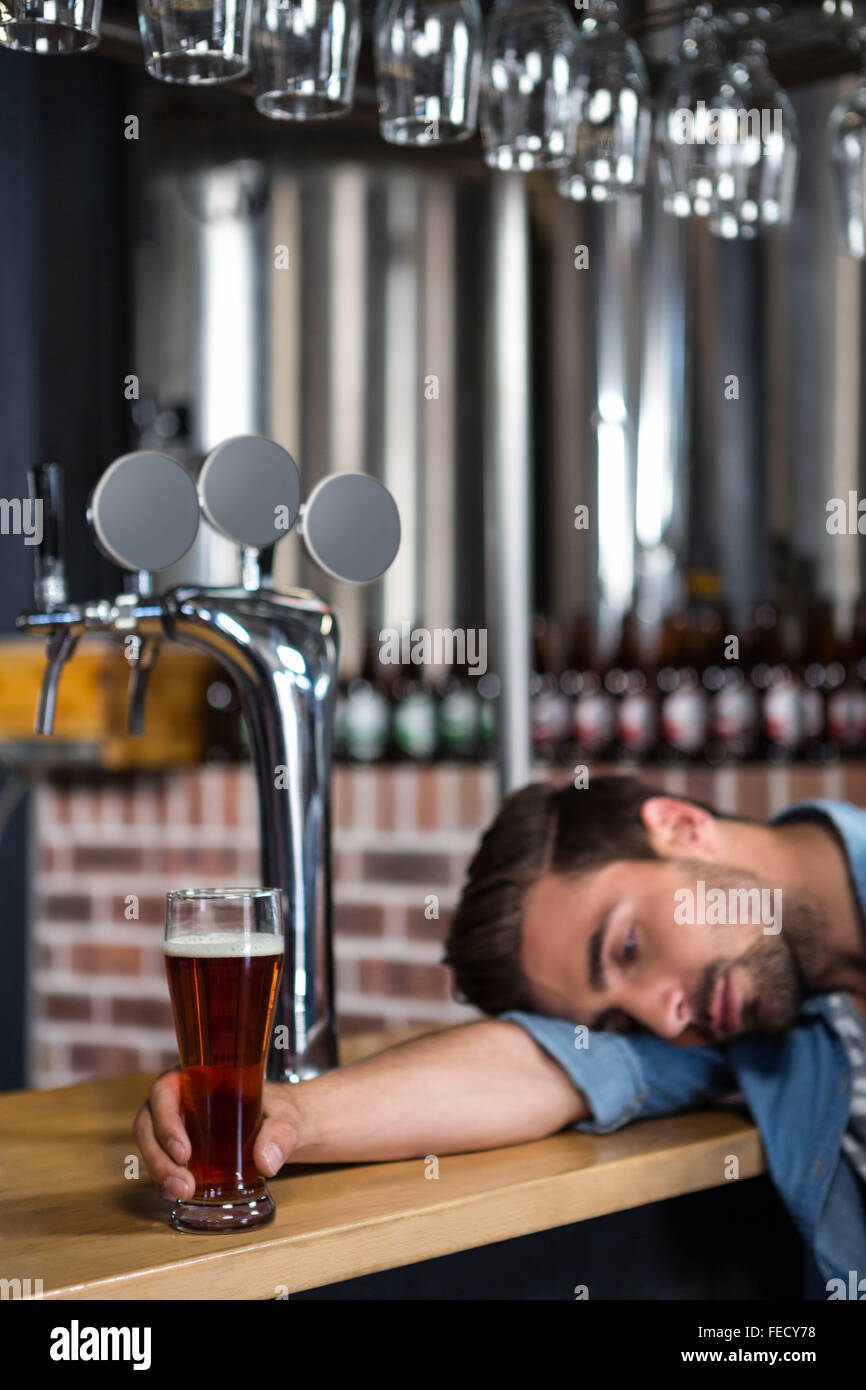 Tired man leaning on counter Stock Photo - Alamy
