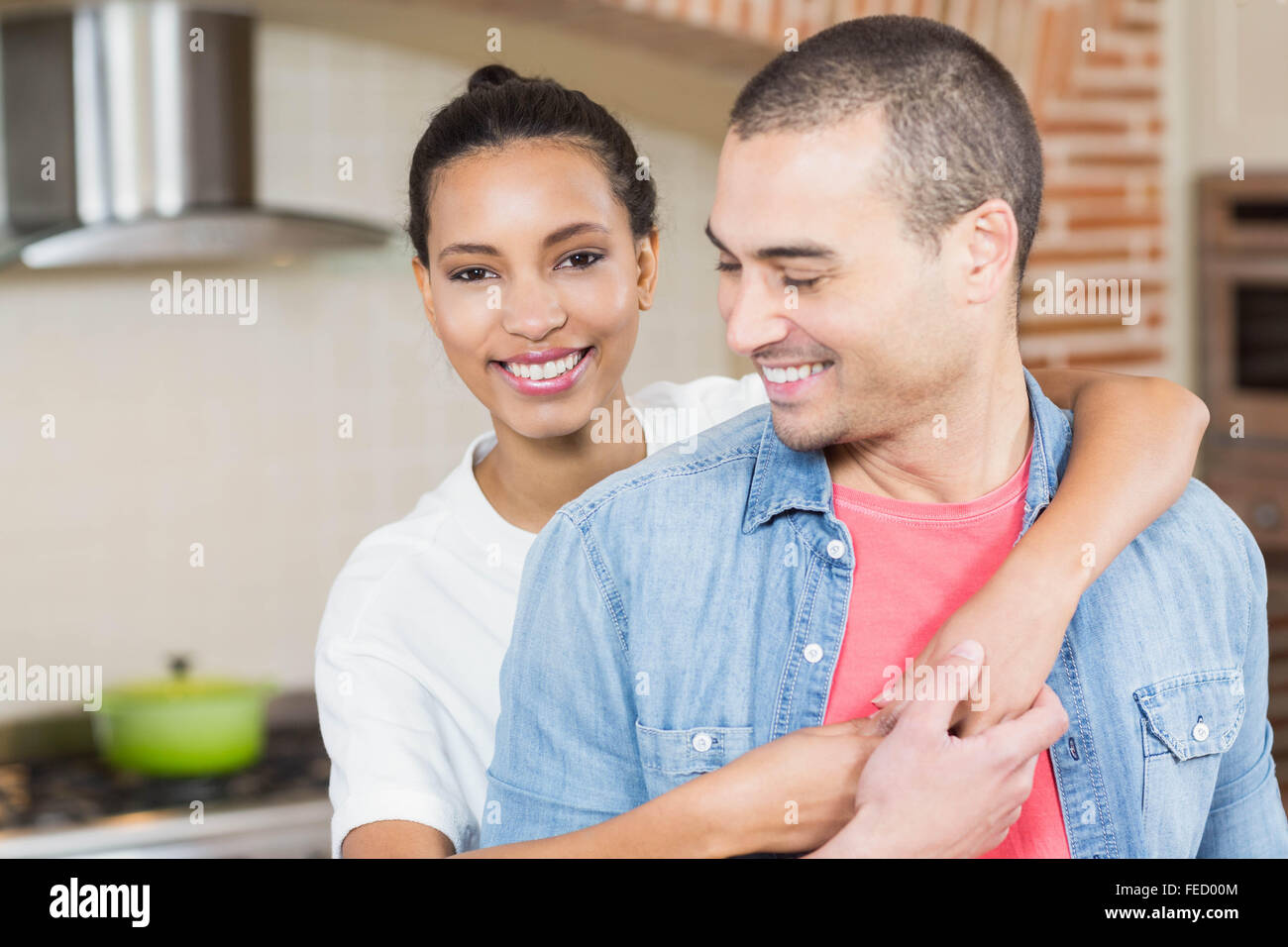 Smiling couple hugging in the kitchen Stock Photo - Alamy