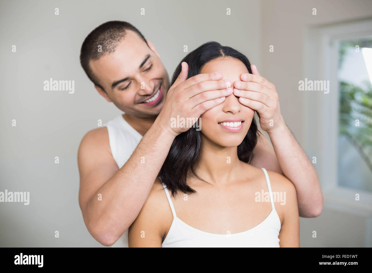Happy husband covering wifes eyes Stock Photo - Alamy