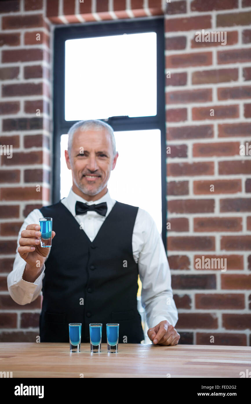 Barman giving blue shots Stock Photo - Alamy