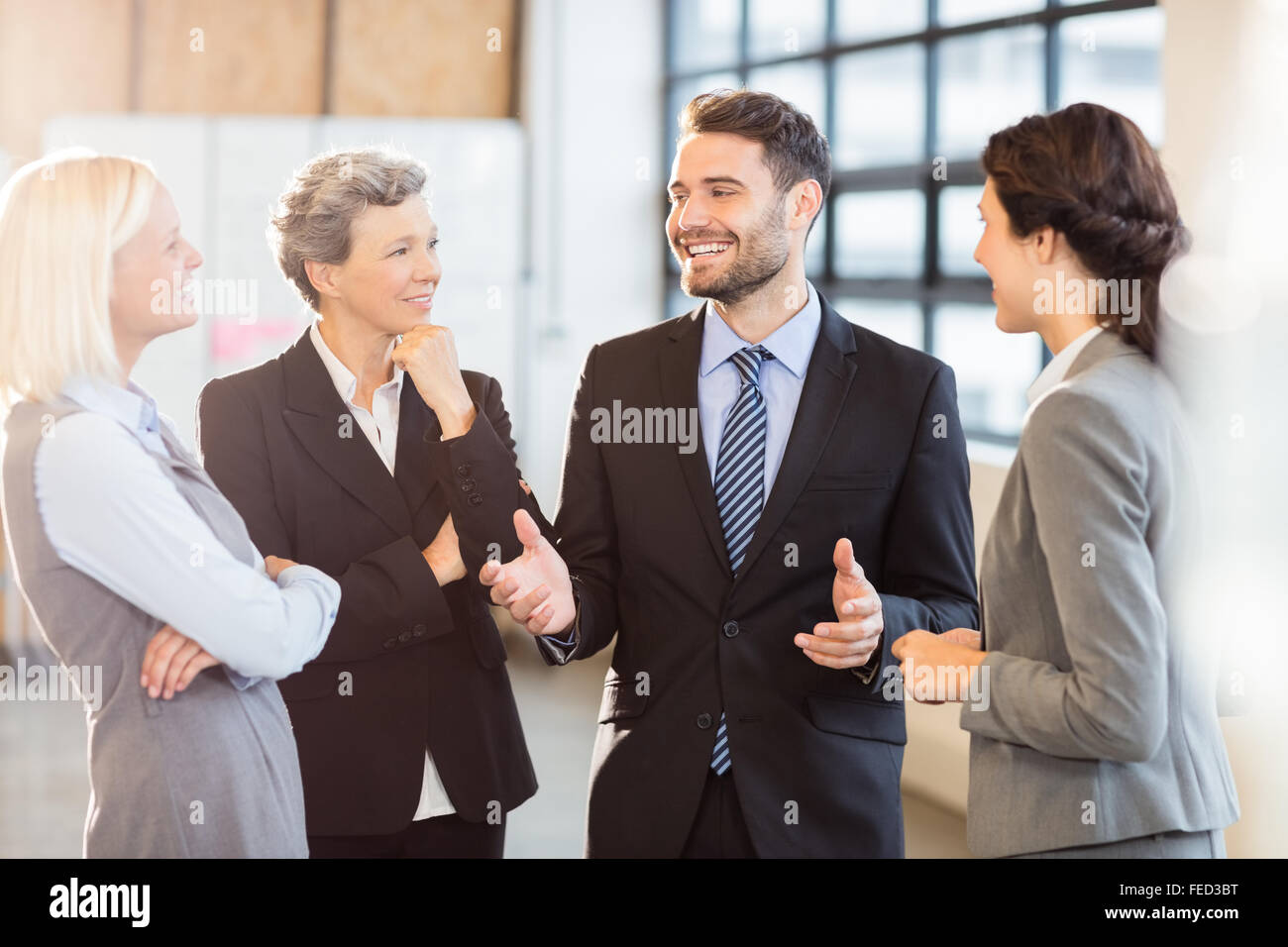 Business team standing and speaking Stock Photo - Alamy