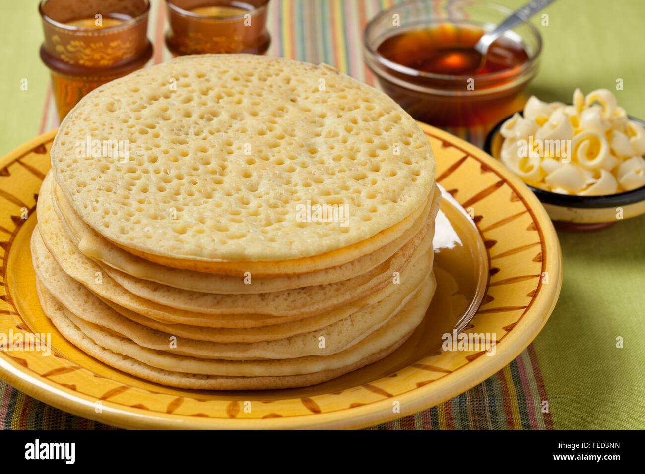 Heap of traditional Moroccan beghrir pancakes served with honey and ...