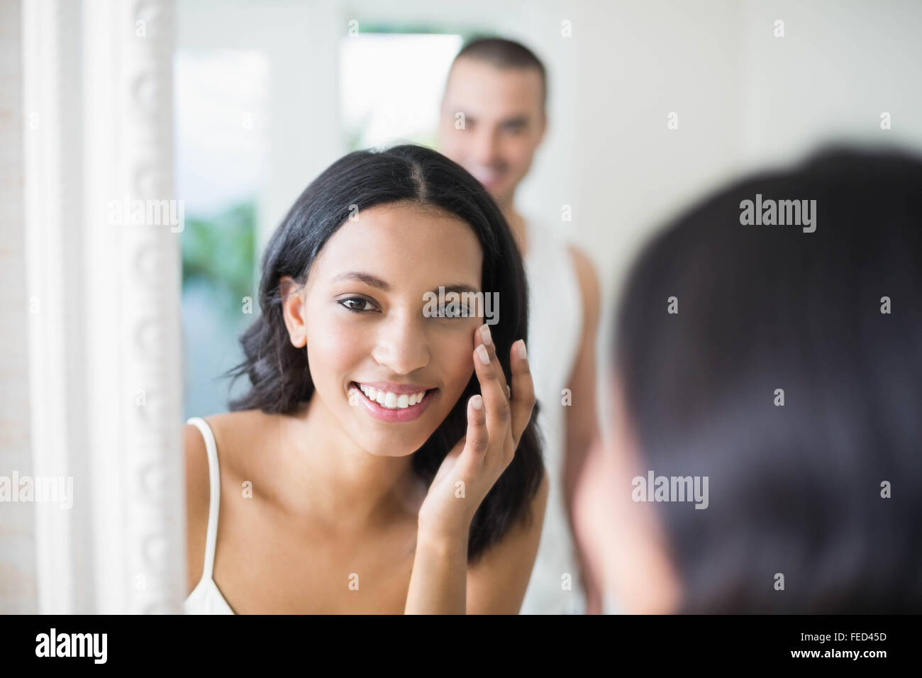 Smiling couple looking at mirror Stock Photo - Alamy